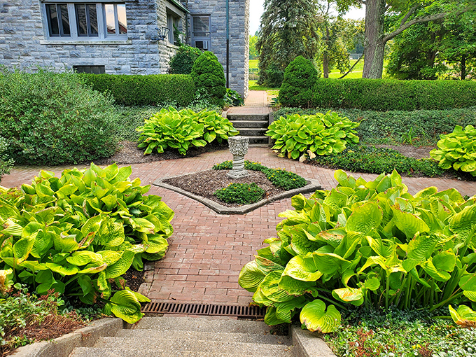 The meticulously maintained gardens feature brick pathways and lush hostas that frame the castle grounds like nature's own royal carpet. 