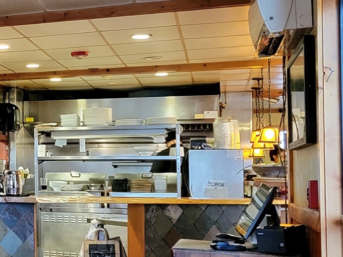 A glimpse into the kitchen reveals the organized chaos where culinary magic happens. Those white plates stand ready for their transformation into edible works of art.
