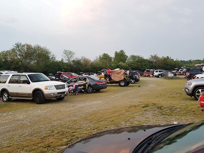 Tailgating meets cinema as families create living rooms on gravel, complete with lawn chairs and coolers. 