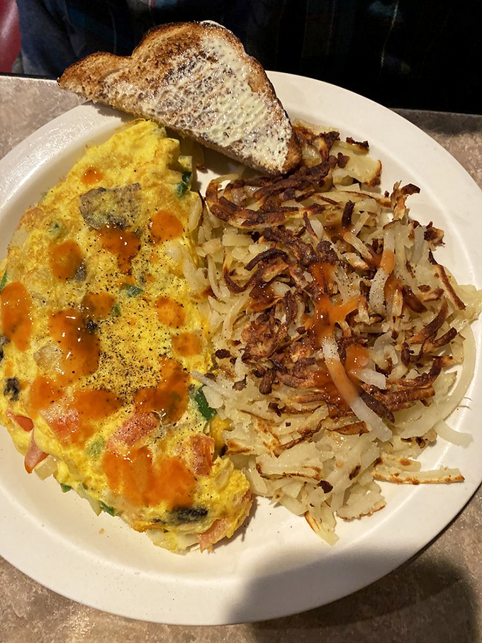 An omelet that's had a meaningful relationship with vegetables. Those hash browns on the side are playing no supporting role.