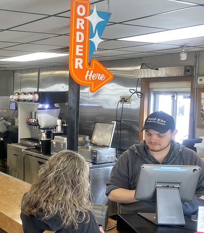 "Order Here" points the way to happiness. The retro arrow sign is as direct as the food philosophy: no fuss, just flavor.