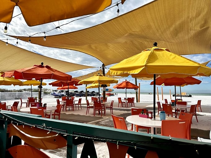Umbrella diplomacy at its finest. The outdoor dining area's canopy of orange and yellow creates a sun-dappled oasis where beach views come complimentary with every meal.