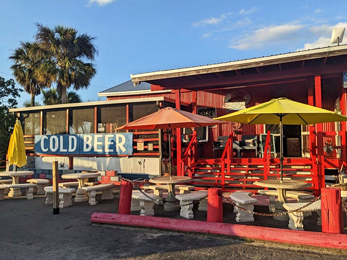 The "COLD BEER" sign isn't just information &ndash; it's a siren call to road-weary travelers promising respite under colorful umbrellas and Florida's endless sky.