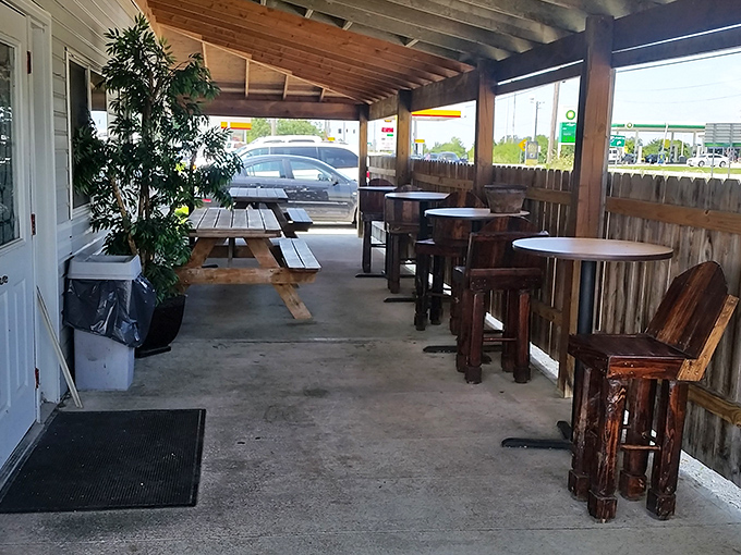 The rustic outdoor seating area features wooden picnic tables and barstools, creating a casual vibe that says "stay awhile, neighbor."