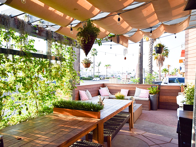 Outdoor seating that brings the garden party vibes. Those hanging plants and palm tree views make "just five more minutes" turn into two more hours.