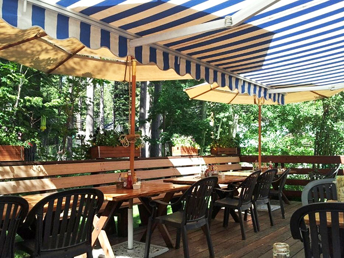 Outdoor dining under blue and white striped awnings &ndash; where fresh mountain air becomes the secret ingredient.