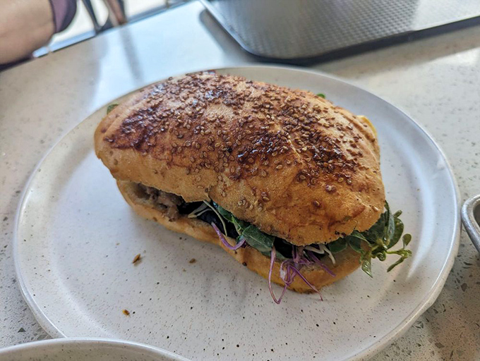 A sandwich that demands two hands and your full attention. Those microgreens aren't just pretty &ndash; they're the perfect counterpoint to rich fillings.