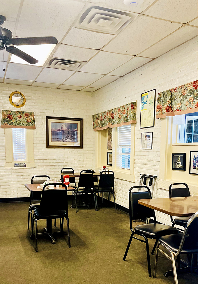 White brick walls, floral valances, and simple tables create that rare dining space where conversations flow as easily as the coffee refills.