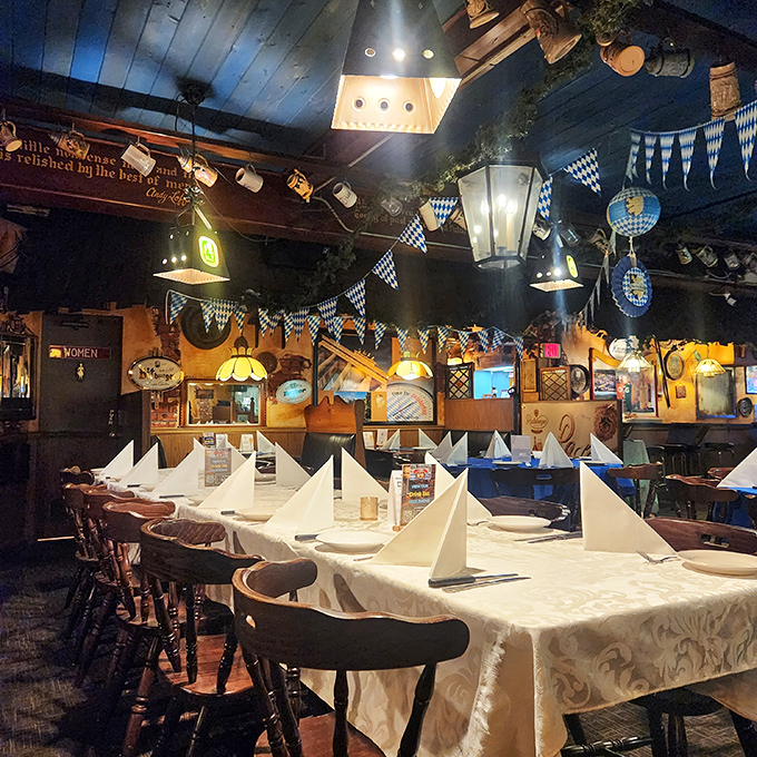 Dining room elegance with Bavarian flair. Blue-and-white checkered pennants hang above meticulously set tables with napkins folded into perfect peaks.