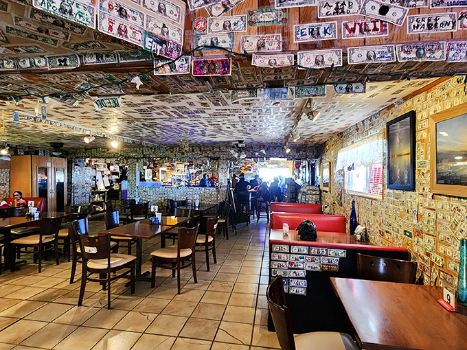 The dining room feels like a museum of American road trips, where every dollar bill tells a story of someone who found this desert oasis.