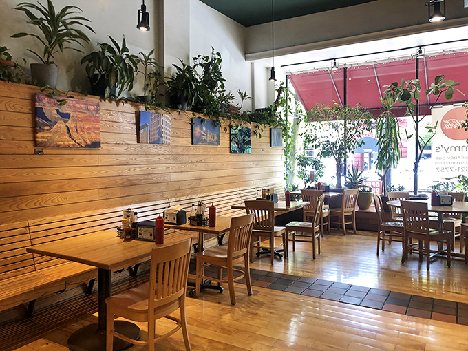 The dining area strikes that perfect balance between cozy and spacious, with plants perched above wooden paneling creating a greenhouse effect that makes everything taste fresher.