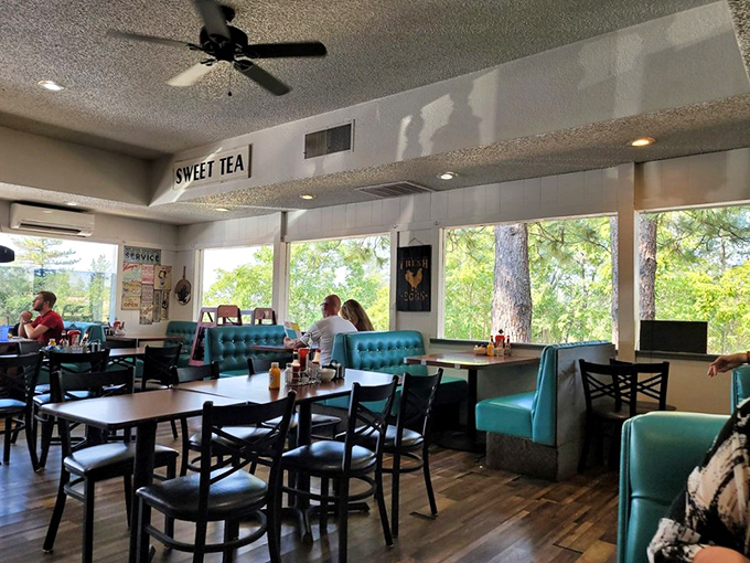 Teal booths frame windows that showcase towering pines outside &ndash; nature's perfect backdrop for contemplating whether to order seconds.