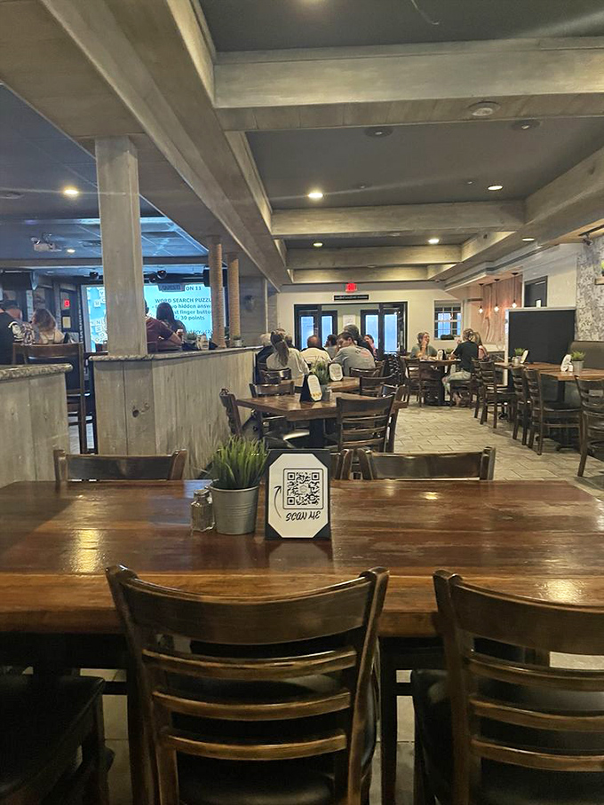 Rustic beams frame a dining room where conversations flow as freely as the drinks. Small potted plants add life to wooden tables where memories are made between bites.