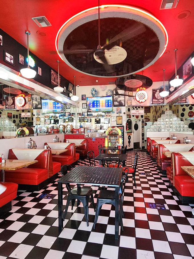 The diner's interior is a masterclass in nostalgic design. Vinyl booths, record d&eacute;cor, and checkered floors create a symphony of mid-century magic.