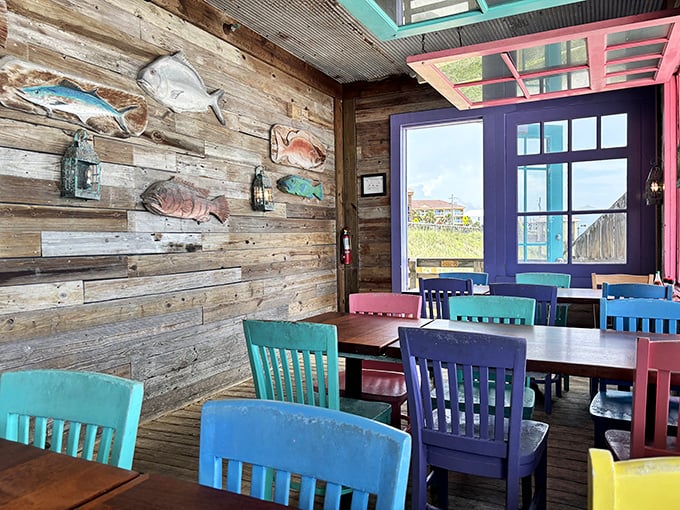 Wooden walls adorned with colorful fish mounts create the perfect backdrop for those vibrant chairs&mdash;like dining inside a cheerful shipwreck.