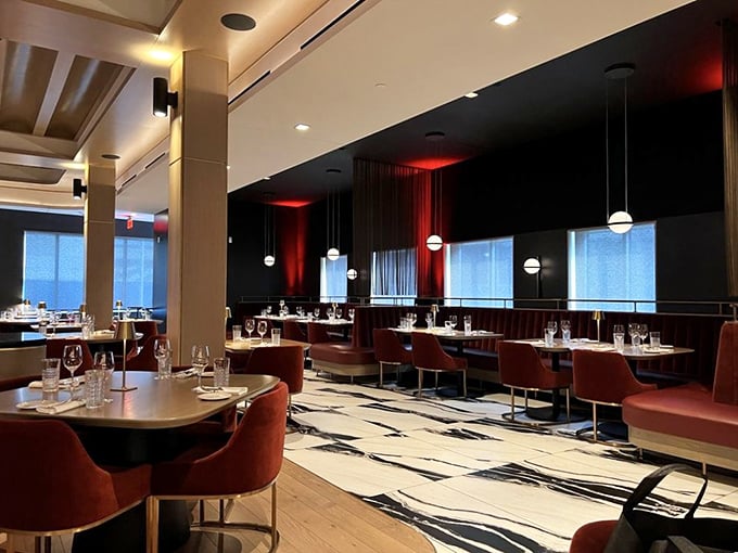 Modern elegance defines Fahrenheit's dining room, where rich burgundy chairs and dramatic lighting create the perfect stage for culinary theater.
