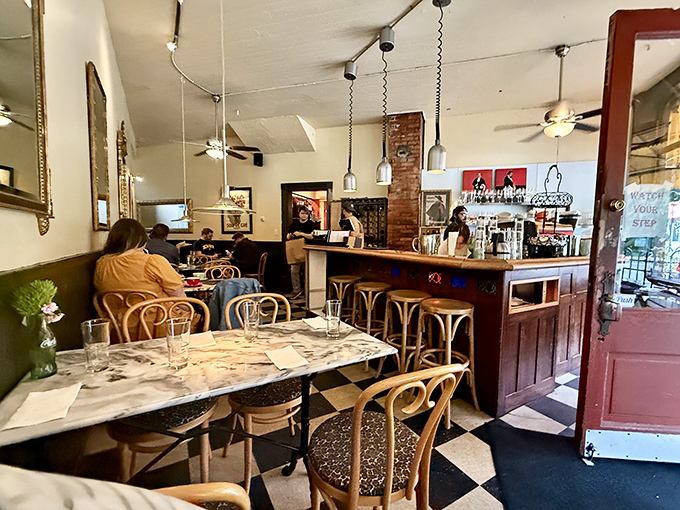 The dining room balances Parisian charm with Midwestern comfort&mdash;vintage mirrors reflect the warm conversations happening at marble-topped tables.
