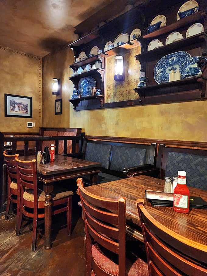 The dining area balances old-world charm with comfortable seating, where blue plates and warm wood create the perfect backdrop for memorable meals.