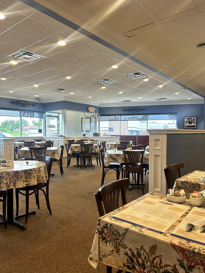Empty tables waiting for their morning guests. The blue walls and floral tablecloths promise a homey breakfast experience.