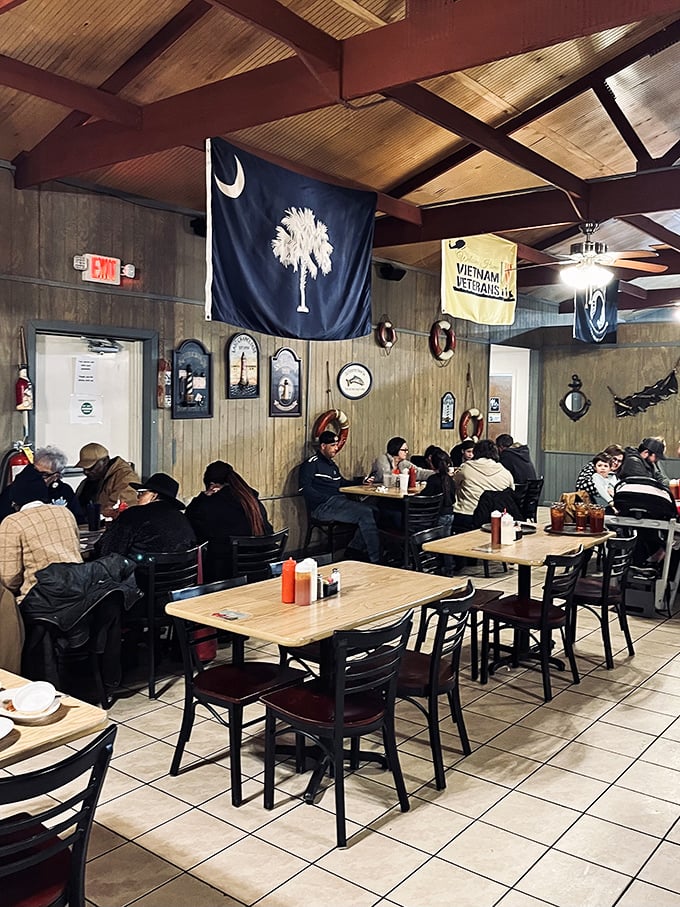 The dining room buzzes with satisfied customers under South Carolina's palmetto flag&mdash;a community gathering spot where seafood brings everyone together.