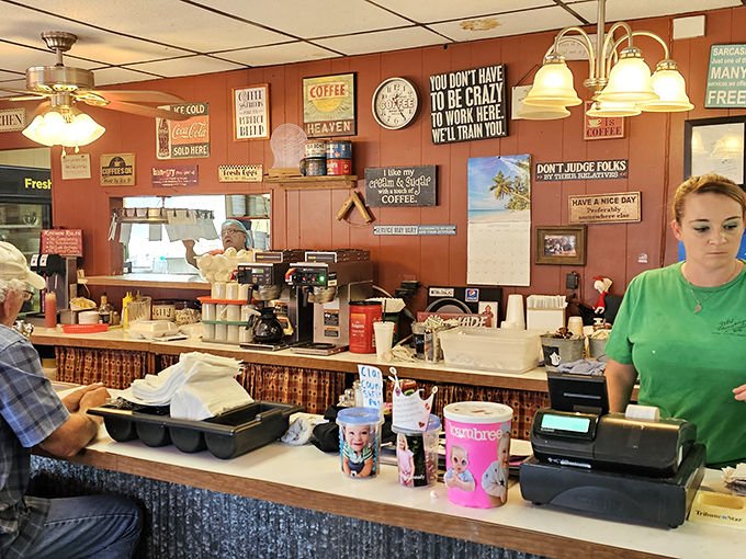 The counter where magic happens. Those humorous signs aren't just decoration; they're the caf&eacute;'s philosophy served with a side of coffee.
