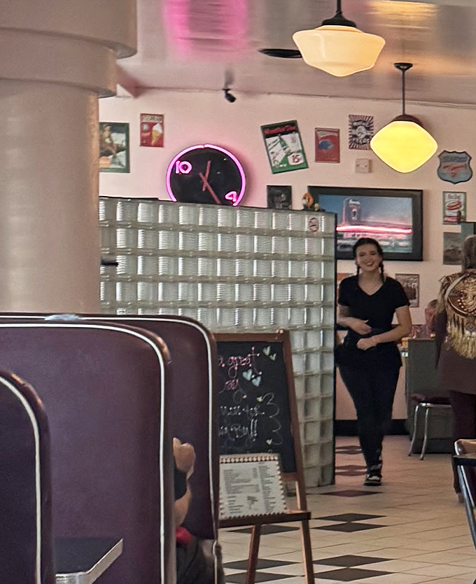 The staff moves with practiced efficiency through the classic black and white tiled space, where neon accents add pops of retro charm.