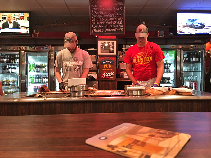 Sandwich artists at work—no pretense, just practiced hands preparing the next round of Pennsylvania comfort food. Baseball caps optional, dedication mandatory.