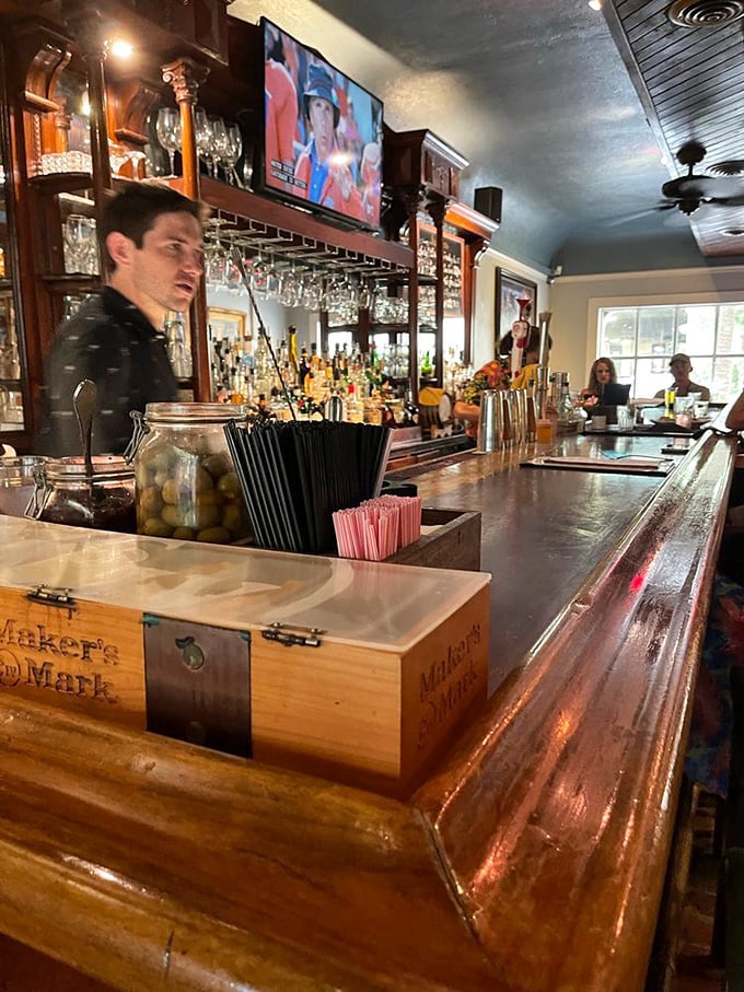 The bar's polished wood surface has heard thousands of toasts and celebrations. The staff creates cocktail theater with practiced precision. 