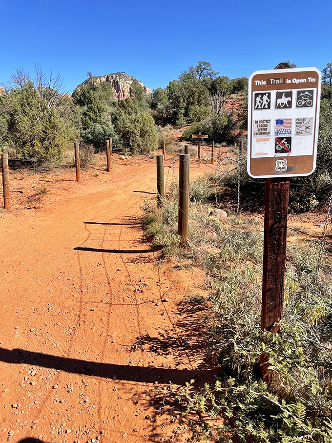 The start of every great adventure begins with a simple sign and a dirt path that promises more than any highway ever could.
