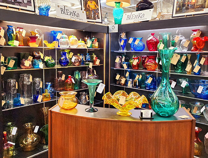 A rainbow of vintage glassware catches the light like liquid jewels. Blenko's signature colors transform ordinary shelves into an art installation.