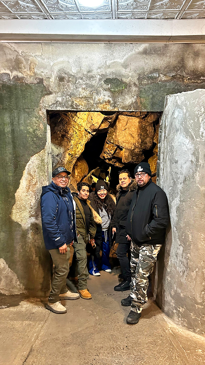 Happy explorers pause at the cavern entrance, bundled up for the consistent 52-degree underground climate - nature's perfect thermostat regardless of season.