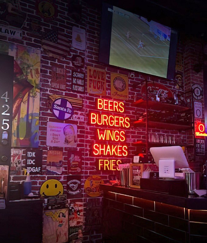 The wall doesn't just display neon&mdash;it broadcasts a siren song of "Beers, Burgers, Wings" that no hungry human can resist.