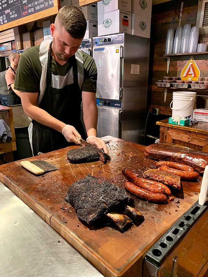 The pitmaster's hands tell stories of predawn fire-tending and years of practice. Watching him slice is like seeing Michelangelo at work, only with more protein.