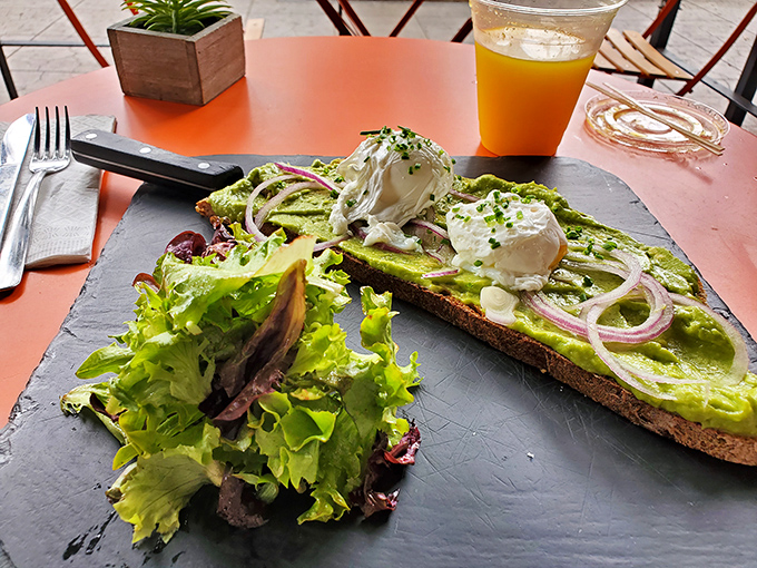 Avocado toast elevated to an art form with perfectly poached eggs and vibrant greens. California and France having a delicious conversation.
