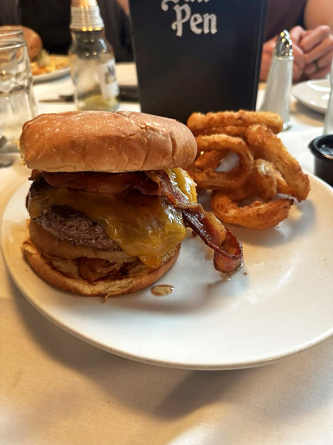 The famous Bull Pen burger with bacon and cheese, accompanied by onion rings that make you question why you'd ever eat vegetables again.