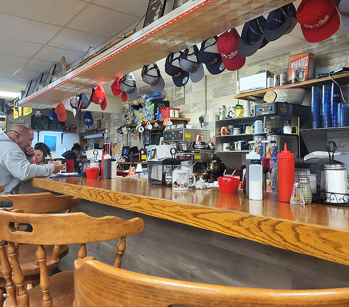 The counter where breakfast dreams come true&mdash;complete with a parade of baseball caps that have witnessed countless "first coffee" moments.