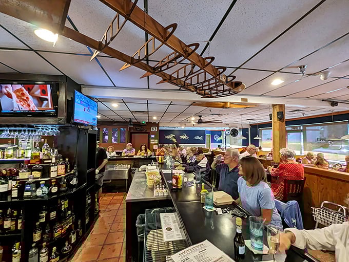 The bar area where regulars exchange fishing stories and food recommendations. That wooden boat hanging from the ceiling isn't just decor&mdash;it's foreshadowing.