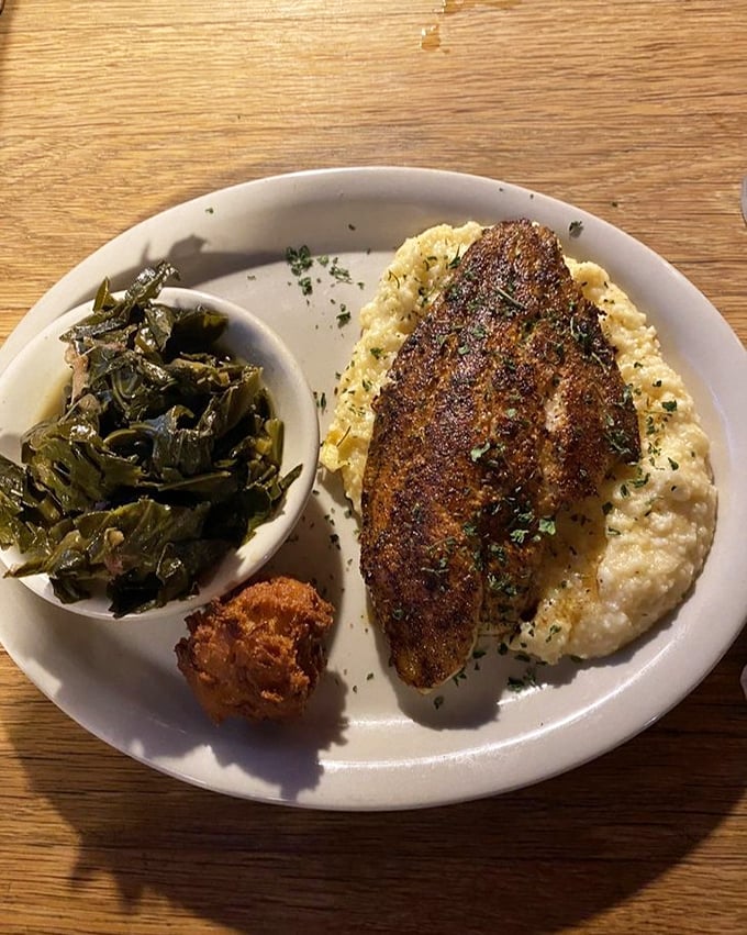 Blackened catfish resting on a cloud of cheese grits with collards on the side&mdash;Southern comfort that hugs you from the inside out.