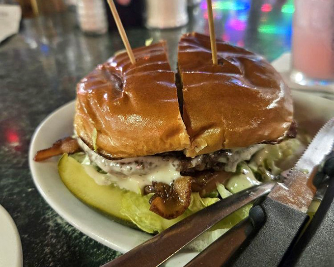 This burger isn't just served &ndash; it's presented with a toothpick flag planted like a delicious conquest, pickle and all.