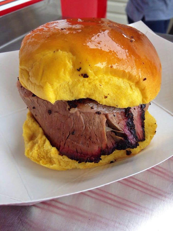 Thick-sliced brisket nestled in a golden bun &ndash; proof that sometimes the simplest combinations yield the most transcendent barbecue experiences.