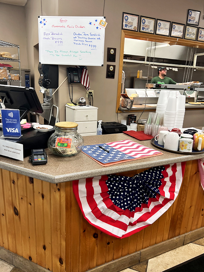 The heart of any great American diner: a counter where regulars perch, staff bustles, and patriotic touches remind you this is hometown America at its finest.
