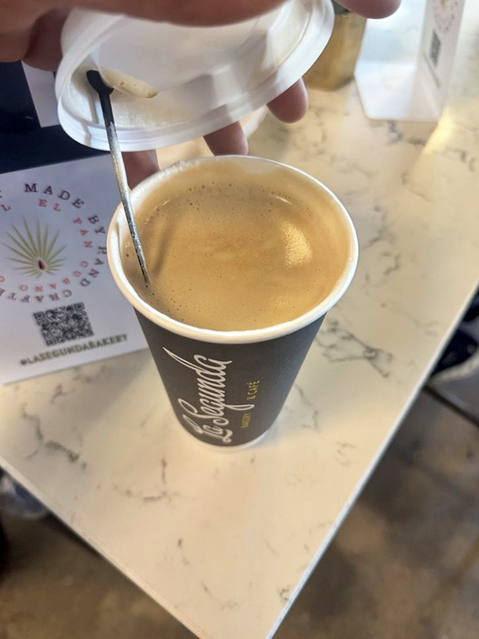 Caf&eacute; con leche&mdash;where coffee meets milk in a dance so perfect it deserves its own Broadway show. The spoon stands by, ready for its stirring solo.