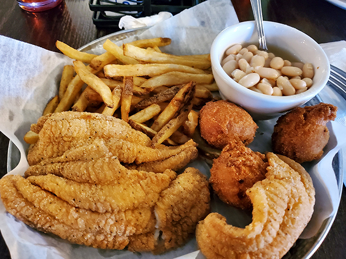 The holy trinity of Southern comfort: golden catfish, crispy fries, and white beans. Paper-lined baskets never held such treasure.