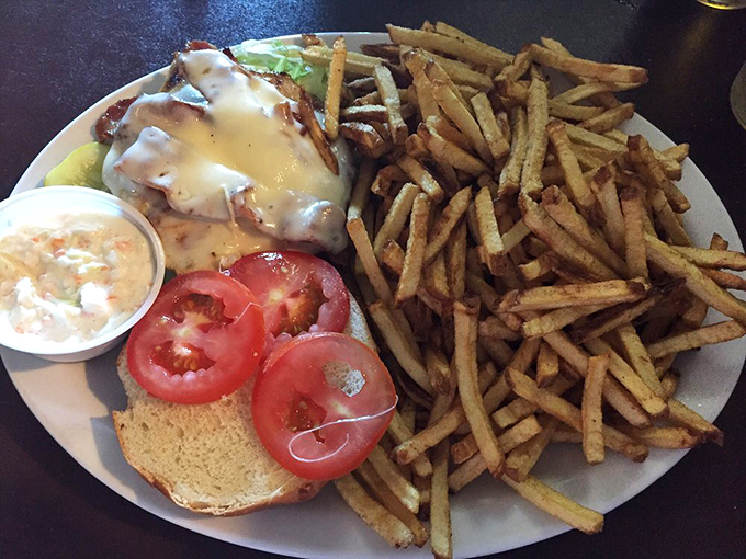 This sandwich practically demands a two-handed commitment. Crispy fries standing at attention beside melty cheese cascading over perfectly cooked protein&mdash;a plate of pure satisfaction.
