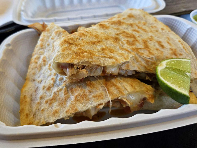 The quesadilla, cut with mathematical precision, reveals its treasure of melted cheese and tender chicken. That lime wedge isn't just garnish - it's essential.