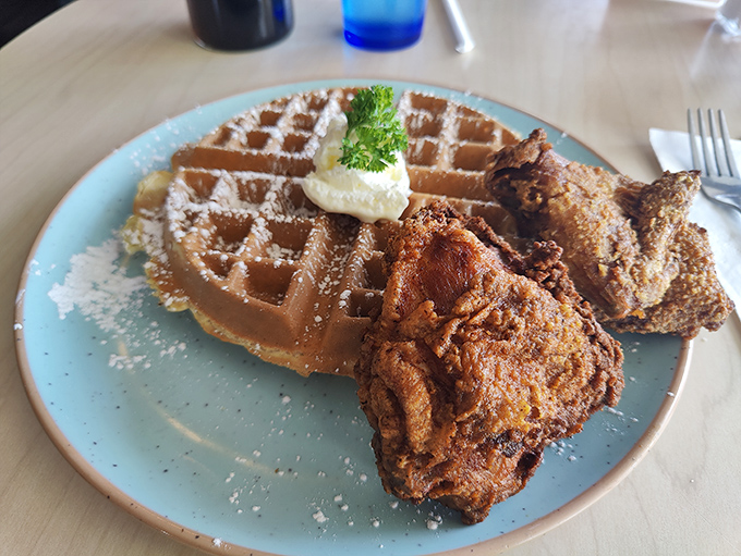 Chicken and waffles: the perfect marriage of sweet and savory, served on a blue plate that makes the golden-brown duo pop like edible celebrities.