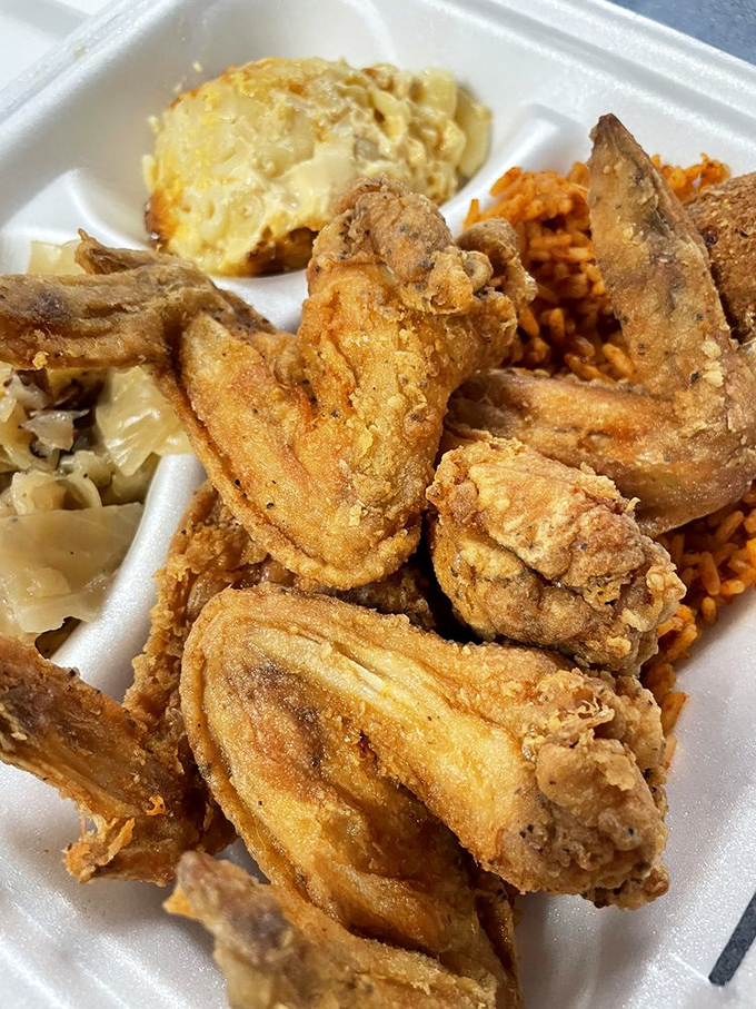 A styrofoam canvas showcasing the holy trinity of Southern cooking: crispy chicken, red rice, and sides that deserve their own fan club.
