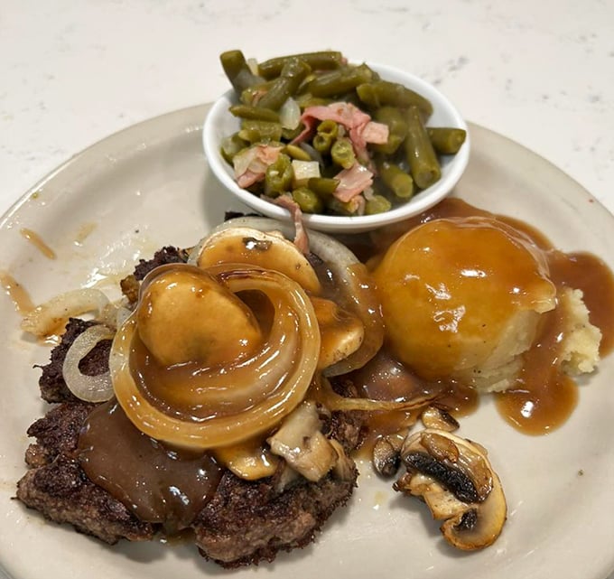 A plate of chopped sirloin smothered in gravy and onions with a side of green beans &ndash; comfort food that speaks directly to your soul.