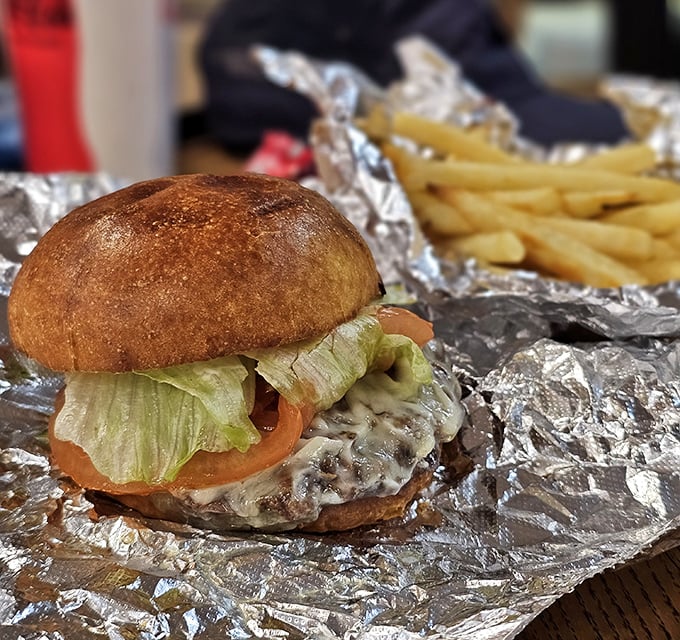 A burger that makes you understand why people used to drive-in for dinner. Served on foil because paper plates would surrender to this juicy masterpiece. 