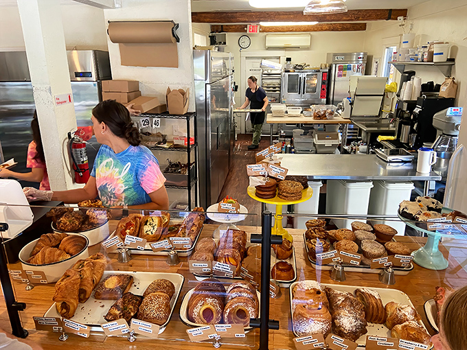 Where the magic happens: a glimpse into the kitchen reveals the organized chaos behind every perfect bite. Those pastry cases are like jewelry displays for edible gems.